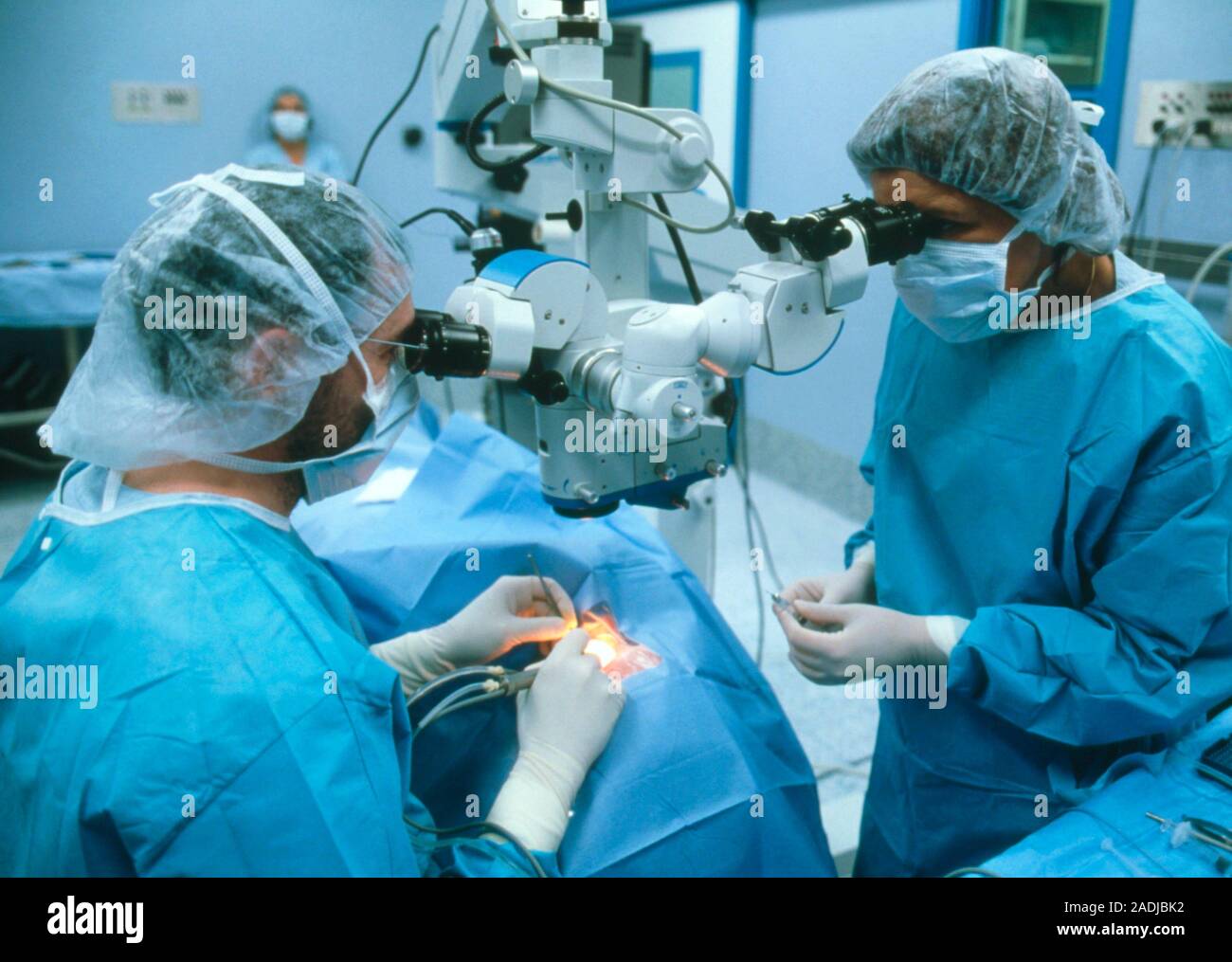 Eye microsurgery. View of surgeons looking through a microscope ...