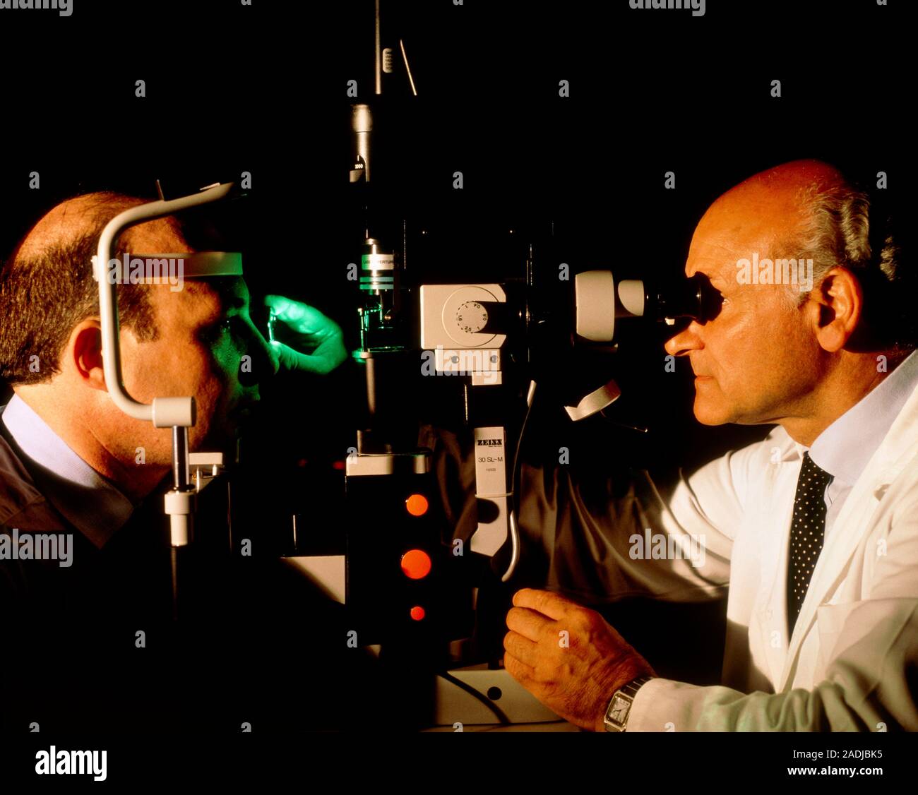 Pre-operative eye examination. Opthalmologist studies the eye of a male ...