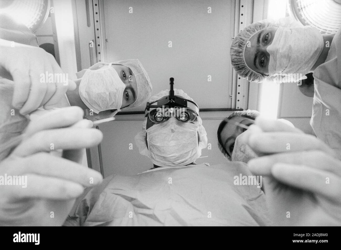 Surgical team. Surgeons performing an eye operation in the operating ...