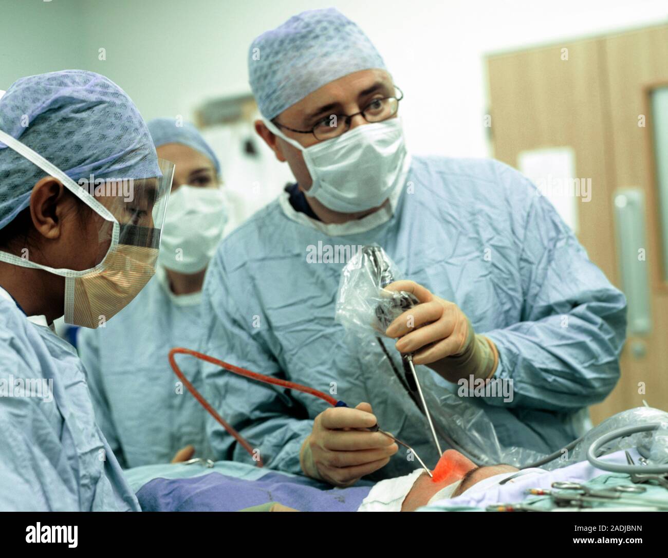 Nasal polyp surgery. ENT surgeon (right) removing a nasal polyp (benign ...