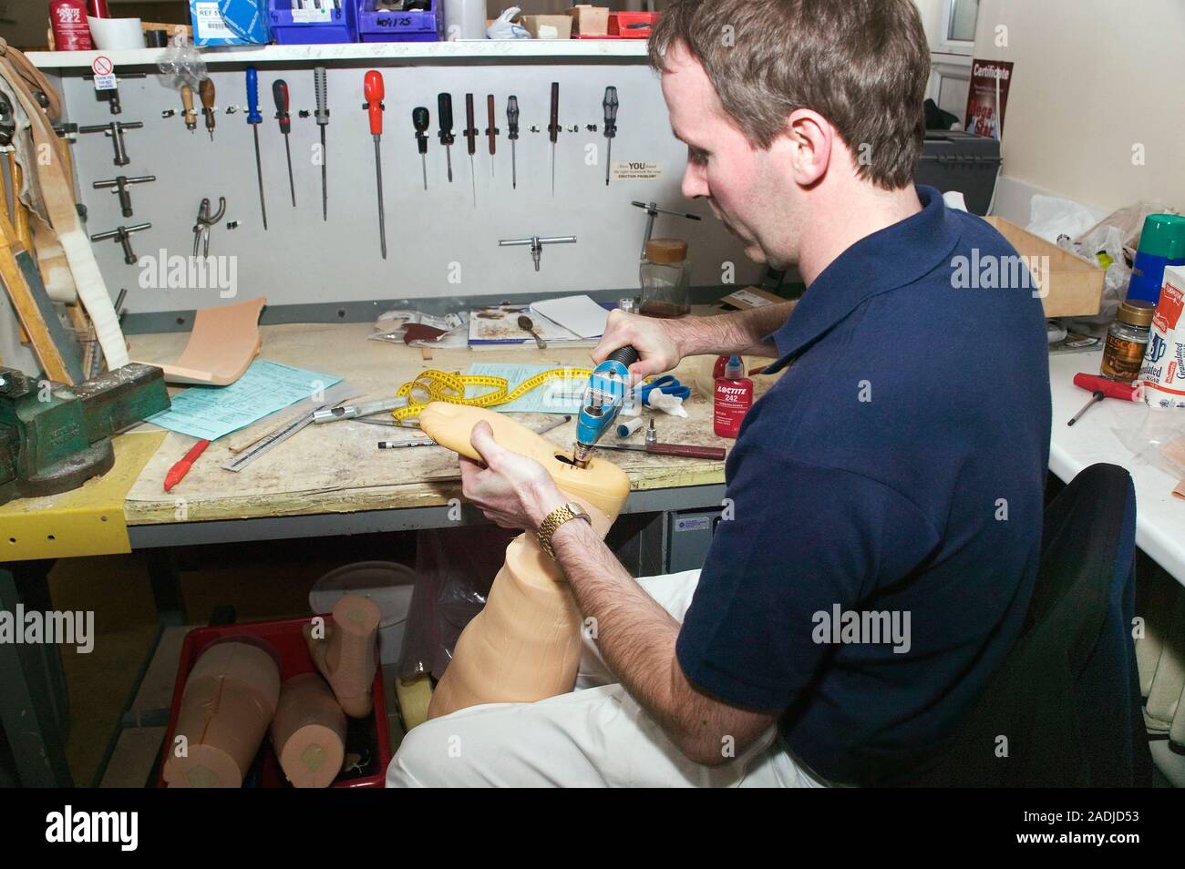 MODEL RELEASED. Prosthetic limb manufacture. Technician building a ...