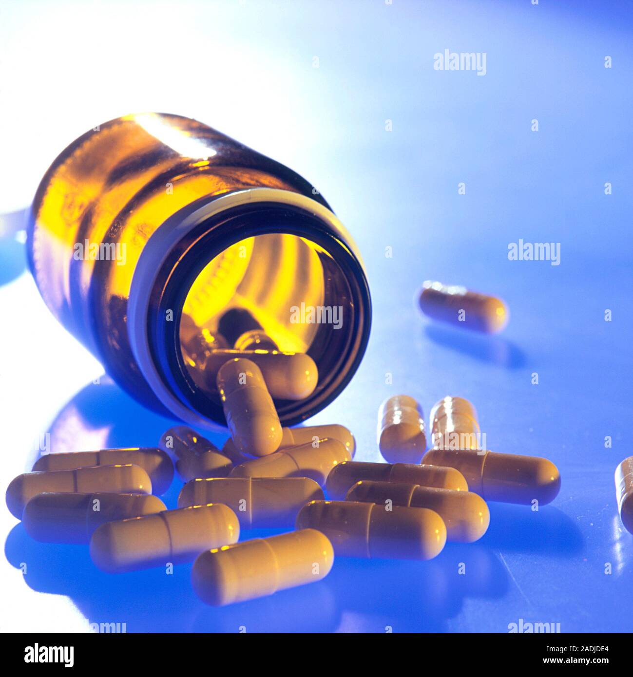 Drug capsules. Drug capsules spilling from a bottle Stock Photo - Alamy