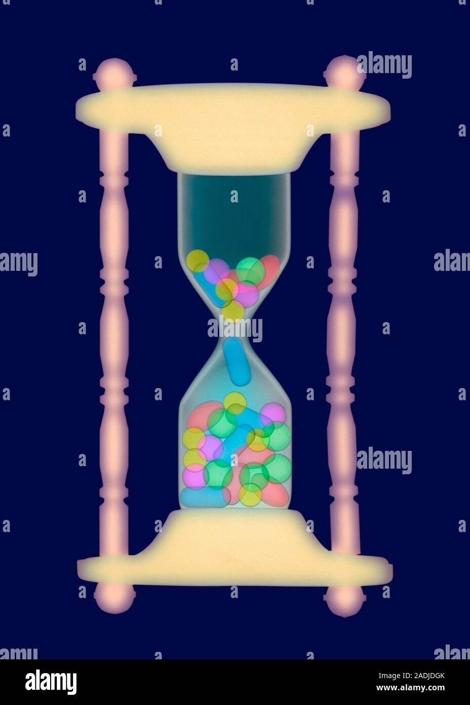 Hourglass. Conceptual coloured X-ray of capsules falling through an ...