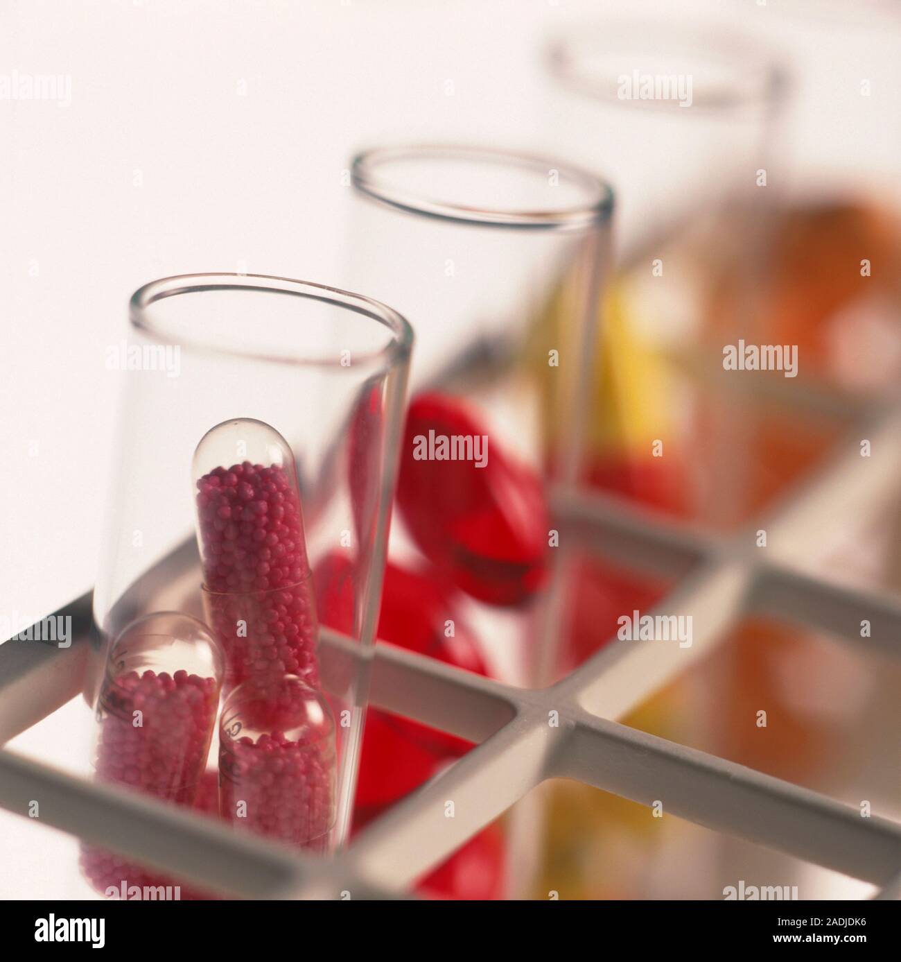 Drug research. Conceptual image of drug capsules in test tubes ...