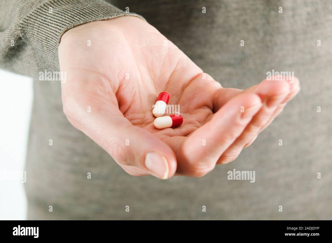 Paracetamol capsules. Two paracetamol painkiller capsules in a man's ...