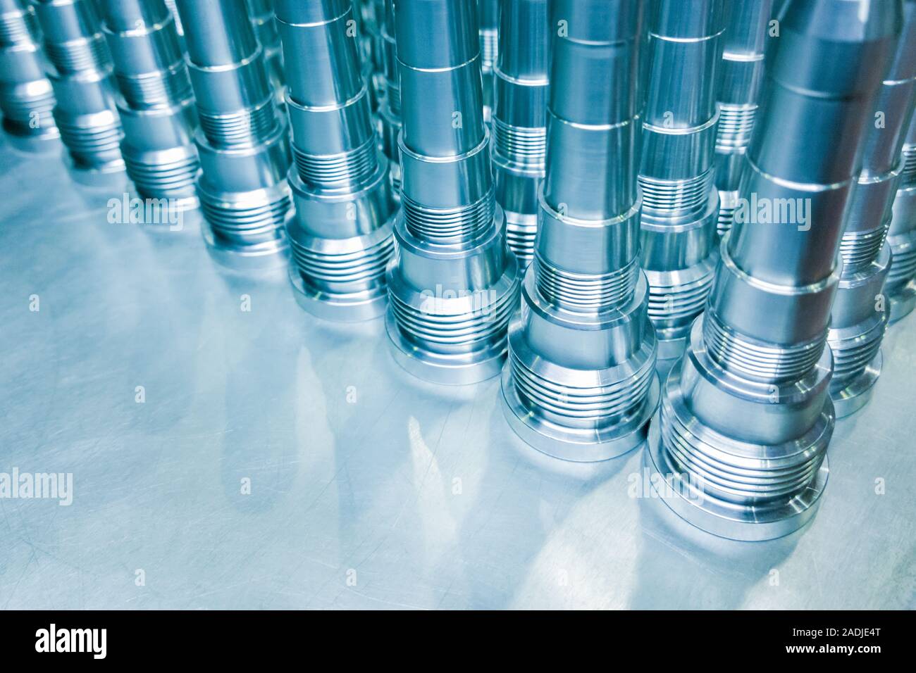 Shiny steel parts background, long clean steel threaded rods after fine ...