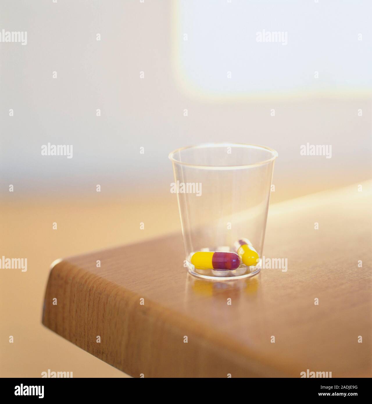 Drug capsules in a beaker on a table Stock Photo - Alamy
