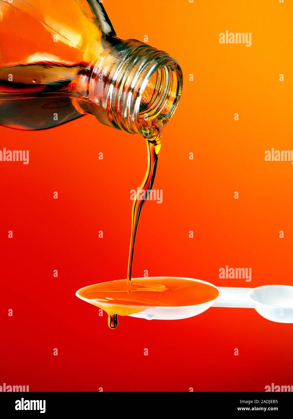 Spoonful of medicine. Pouring a liquid medicine from a bottle into a 5 ...