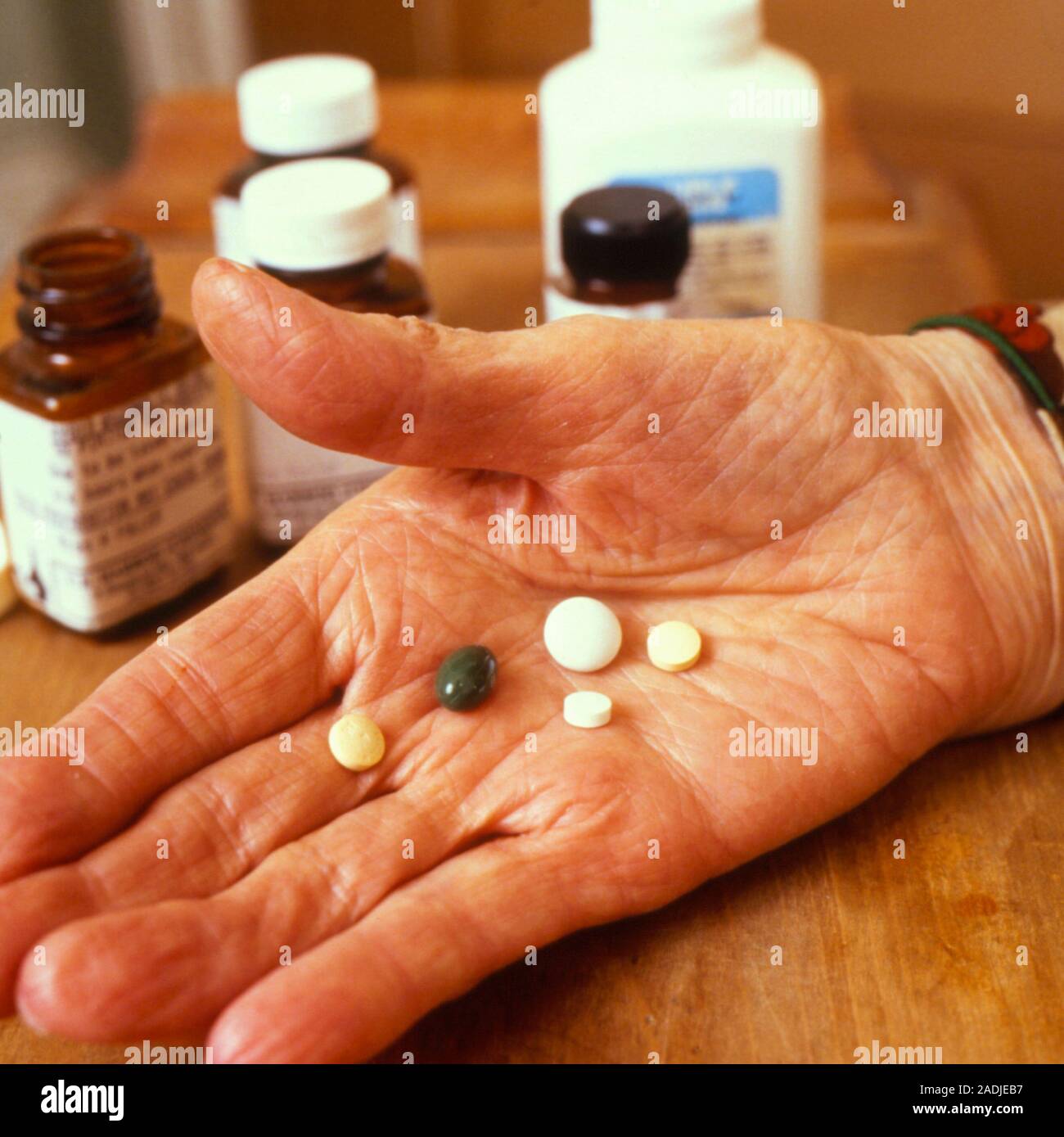 Geriatric medication: elderly woman's hand holding the assortment of ...