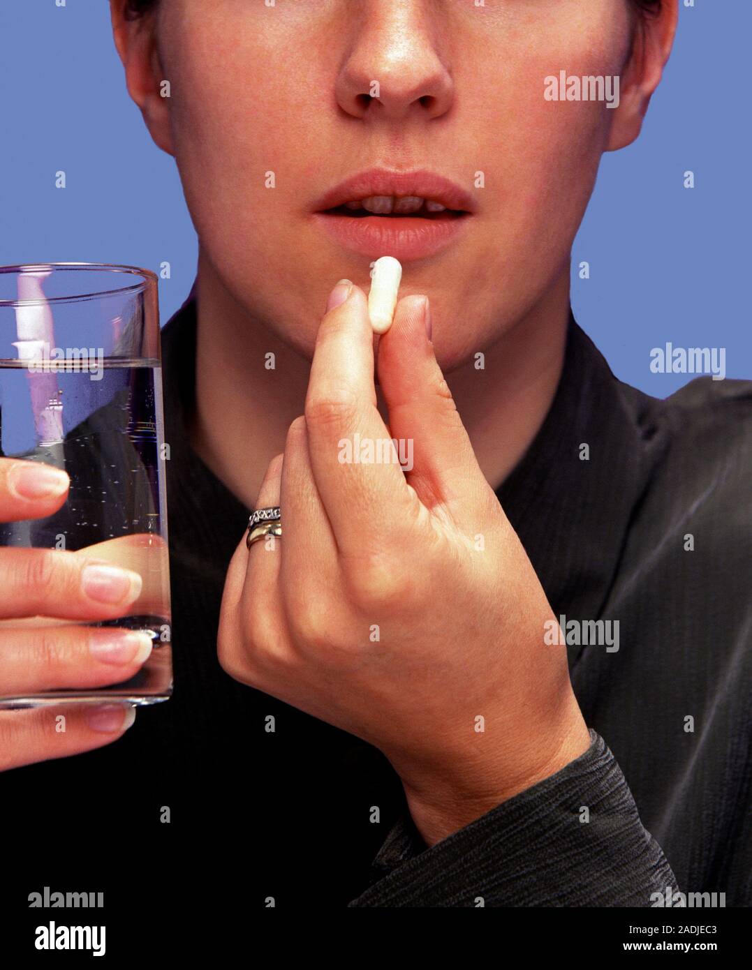 Taking capsule. Woman about to swallow a drug capsule Stock Photo - Alamy