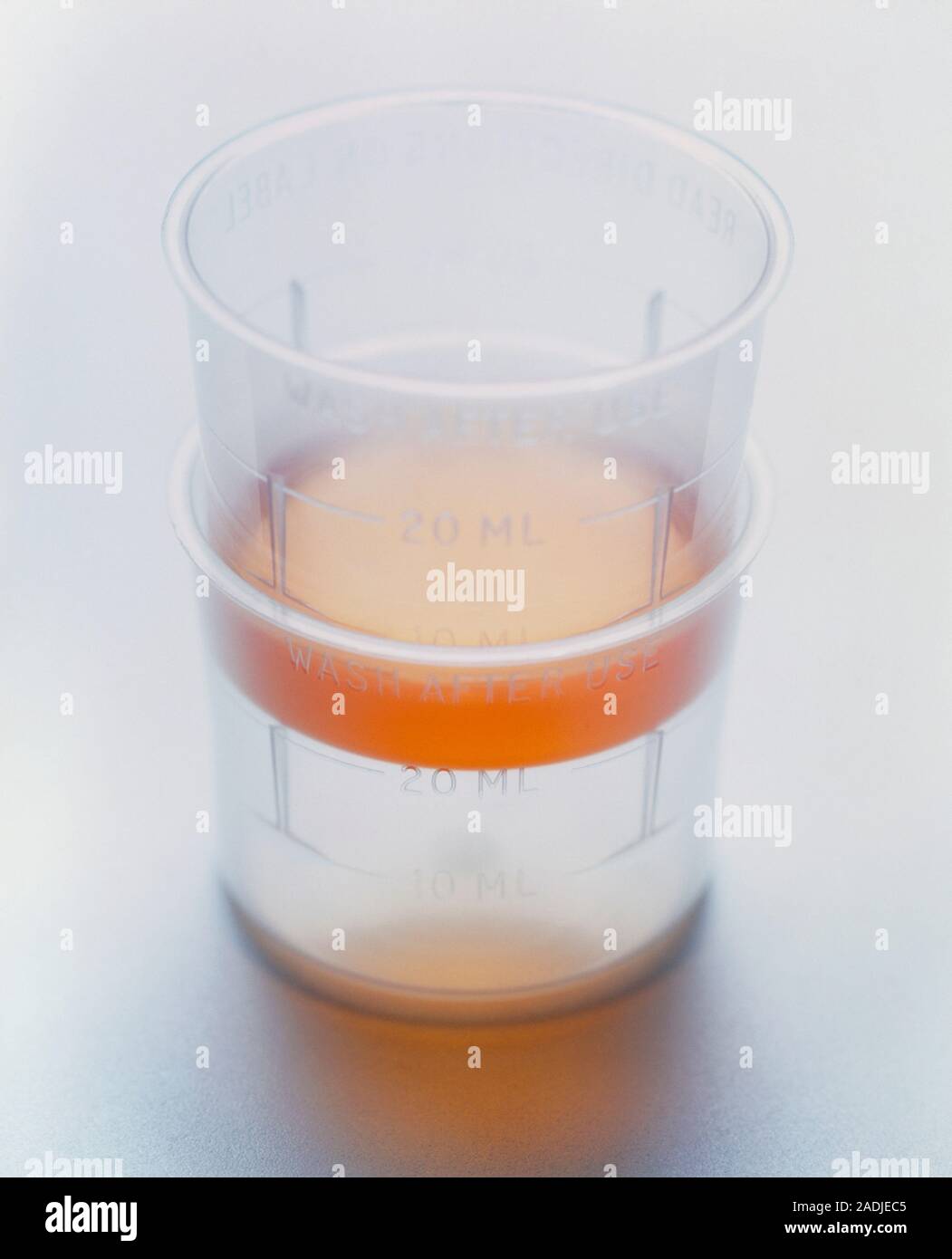 Cup of medicine. Two plastic cups, one containing a liquid medicine ...