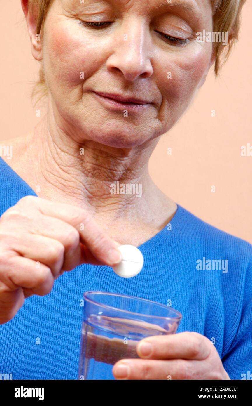 MODEL RELEASED. Indigestion tablet. Woman about to put dissolve an ...
