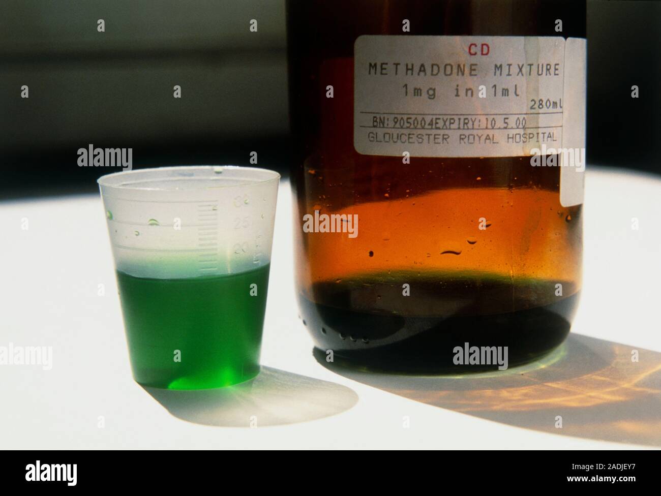 Methadone. Bottle containing the drug methadone and a measure of the ...