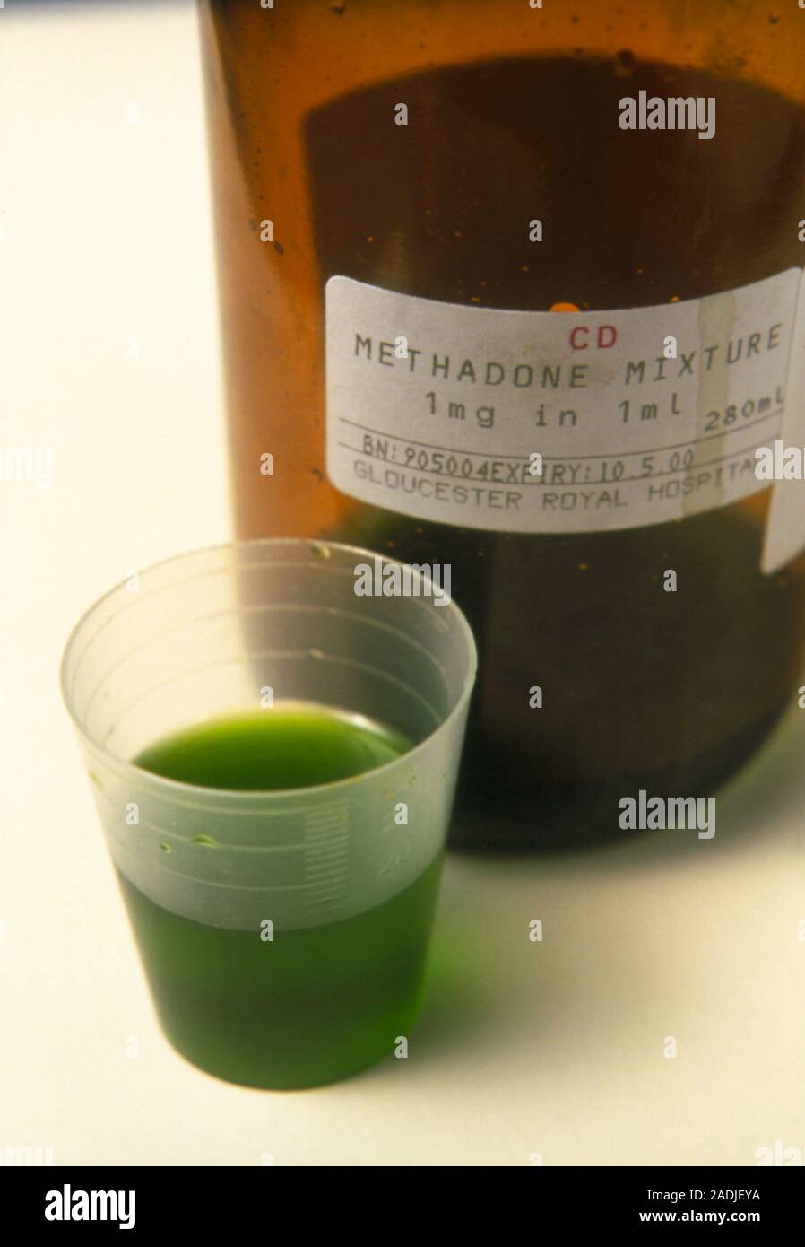 Methadone. Bottle containing the drug methadone and a measure of the ...