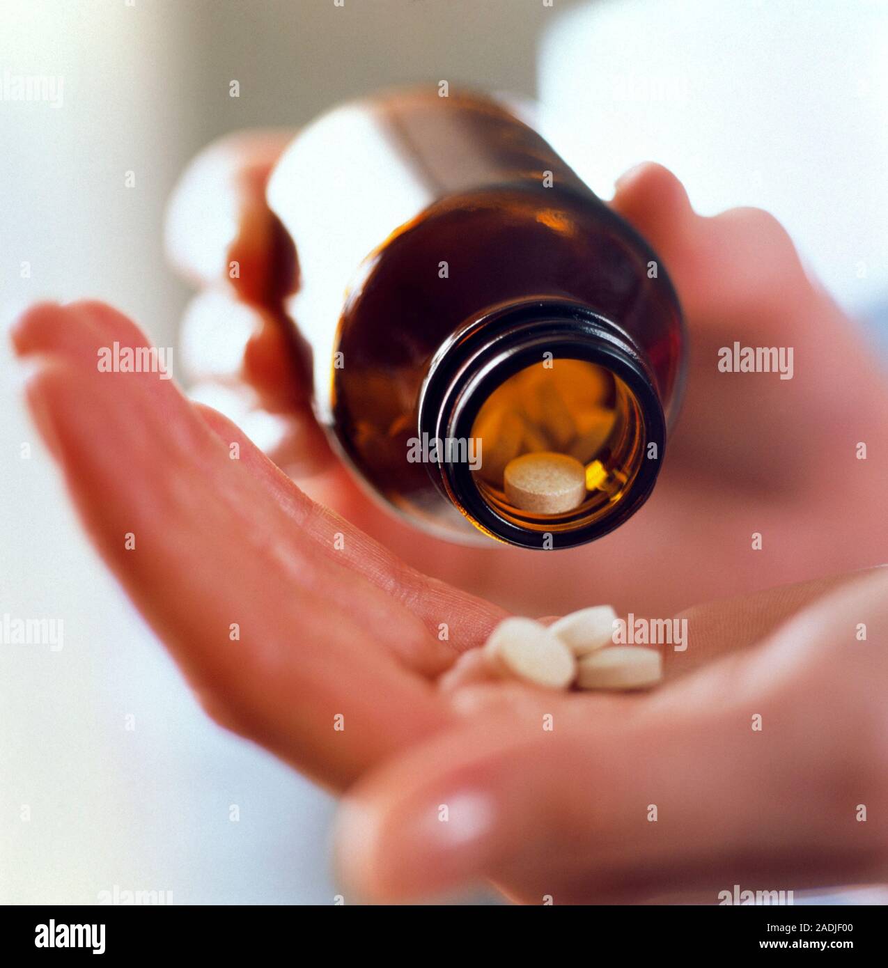 Pain killers. Hand pouring out pain killer (or analgesic) pills from a ...