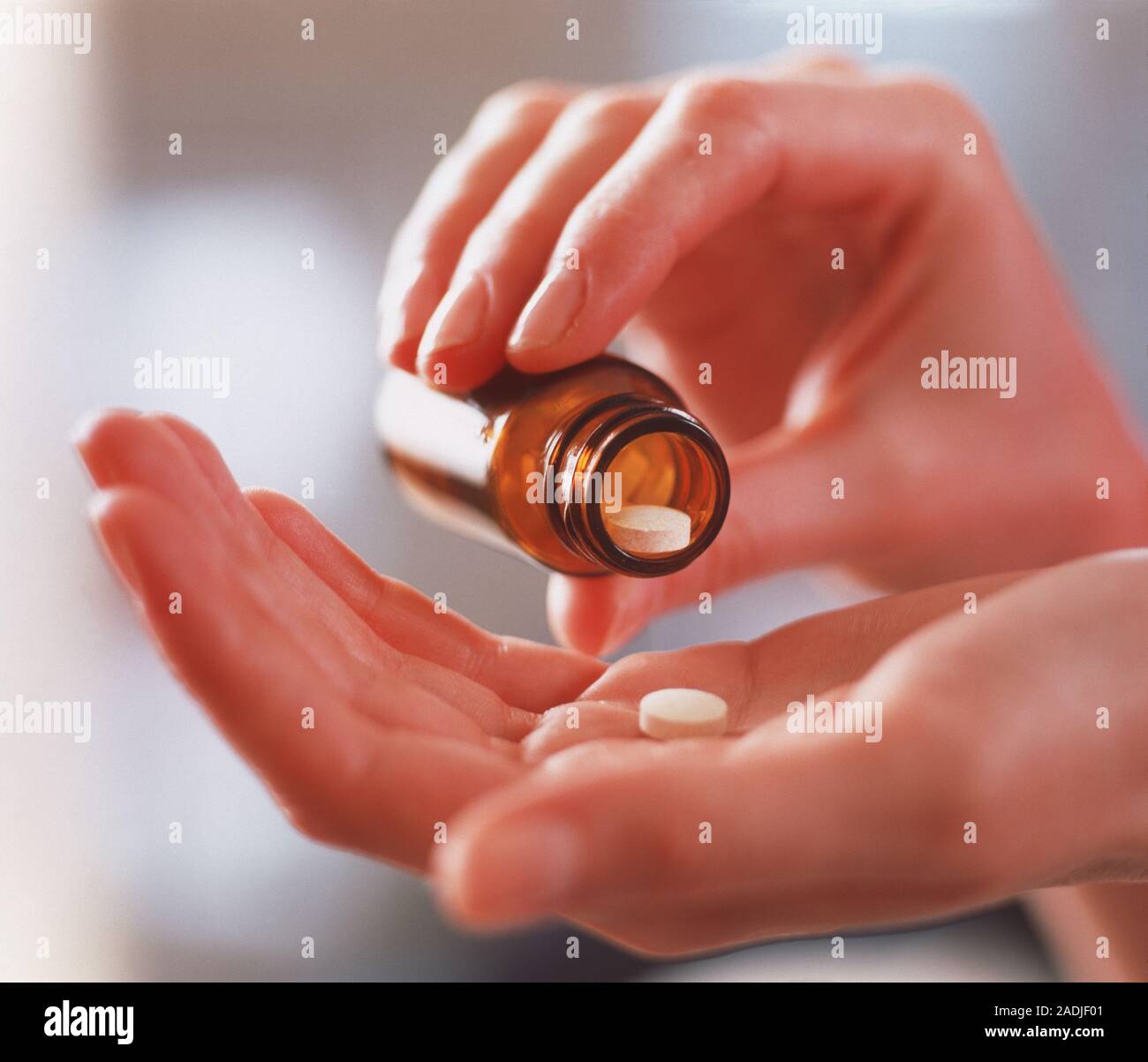 Pain killers. Hand pouring out pain killer (or analgesic) pills from a ...