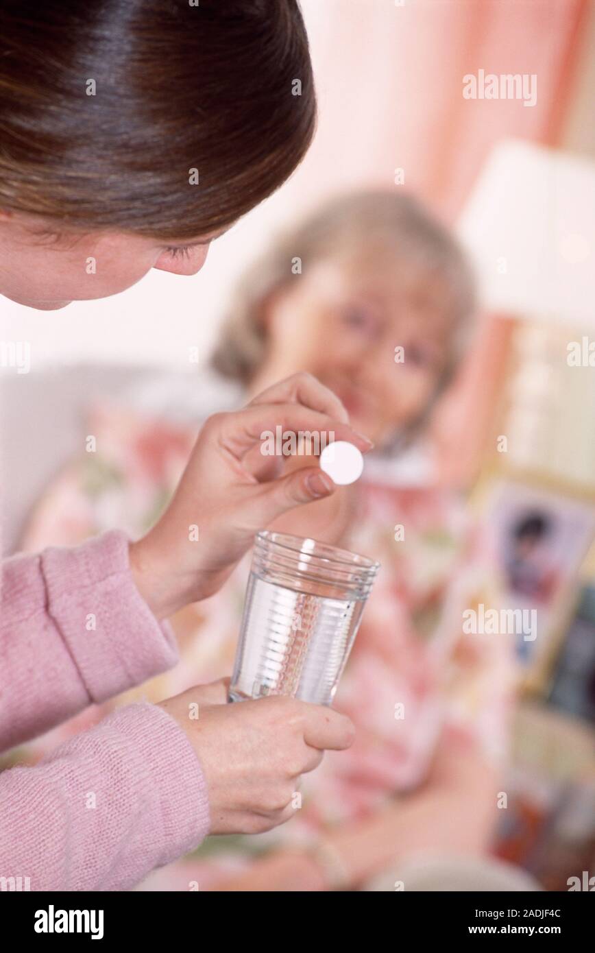 Taking aspirin. Woman placing a tablet of the painkilling (analgesic ...
