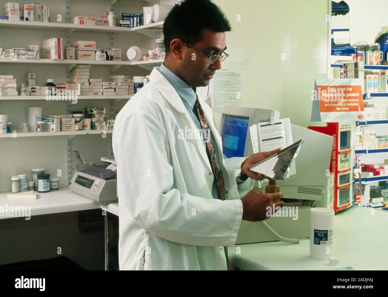 Pharmacist. View of a pharmacist counting out tablets of a drug for a ...