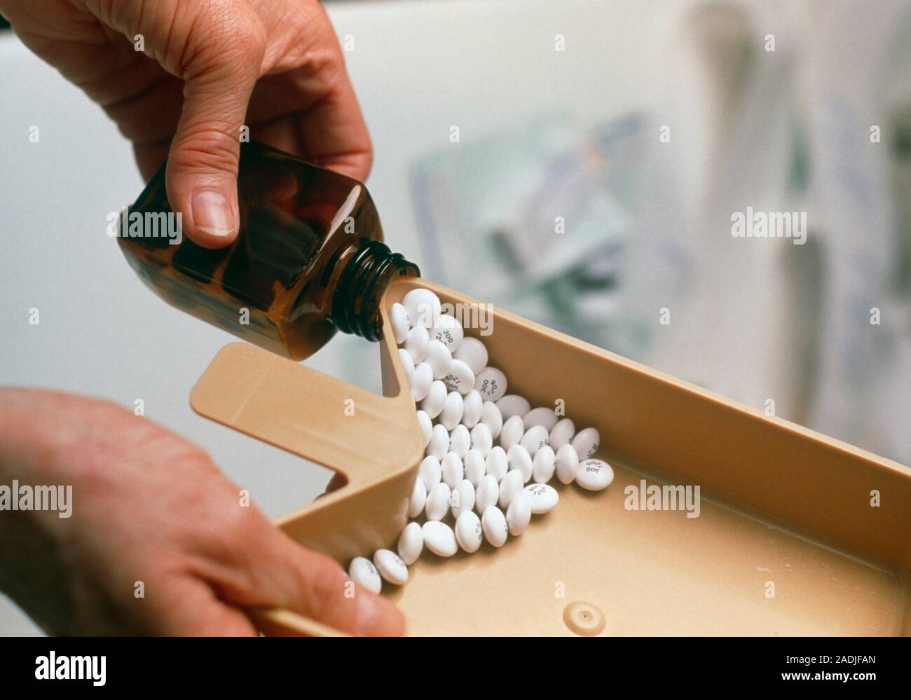 Drug prescription. Hands of a pharmacist counting out pills into a ...