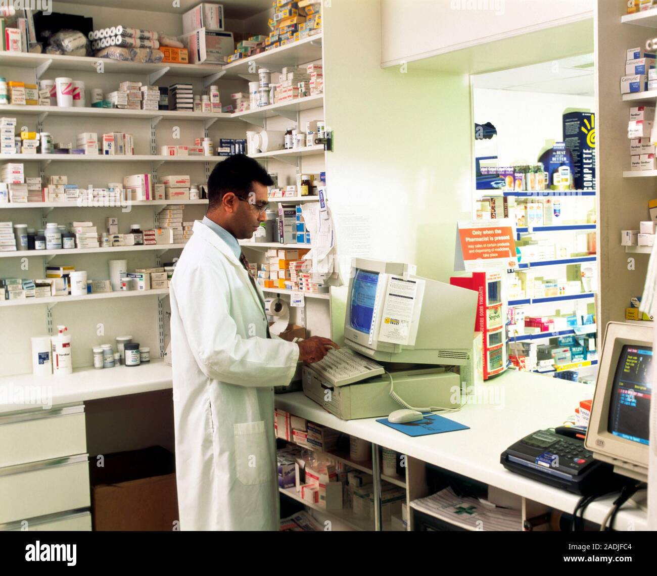 Pharmacist. View of a pharmacist using a computer to fill in a patient ...