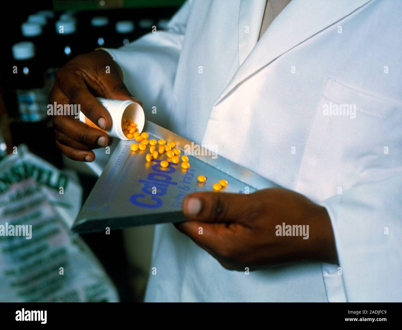 Pharmacist. Pharmacist counting out pills of the drug orphenadrine for ...