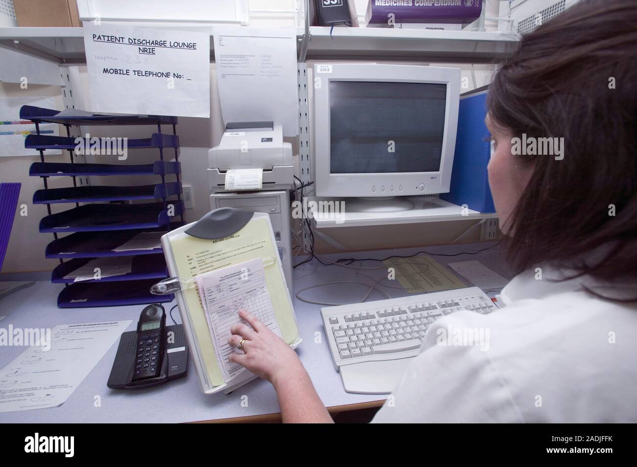 MODEL RELEASED. Drug label printing. Pharmacist in a hospital pharmacy ...