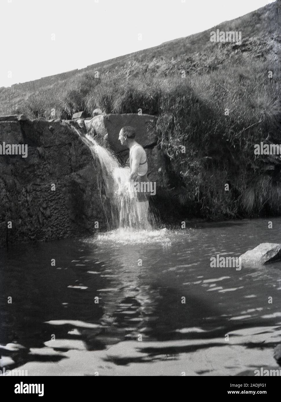1920s, historical, man standing in a river having a shower under fresh ...