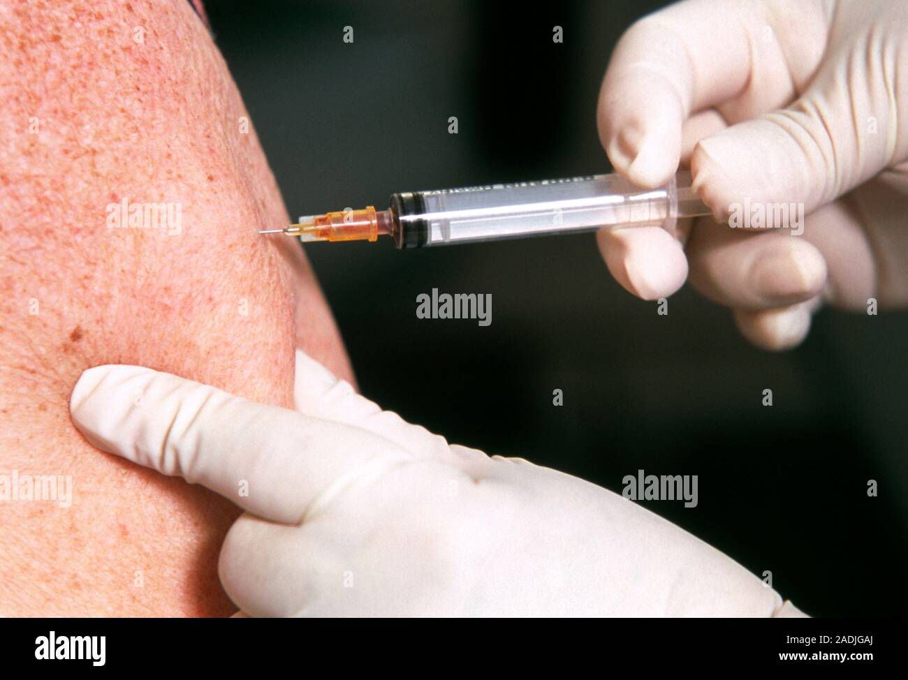 Injection. Close-up of a syringe being used to inject a drug or vaccine ...