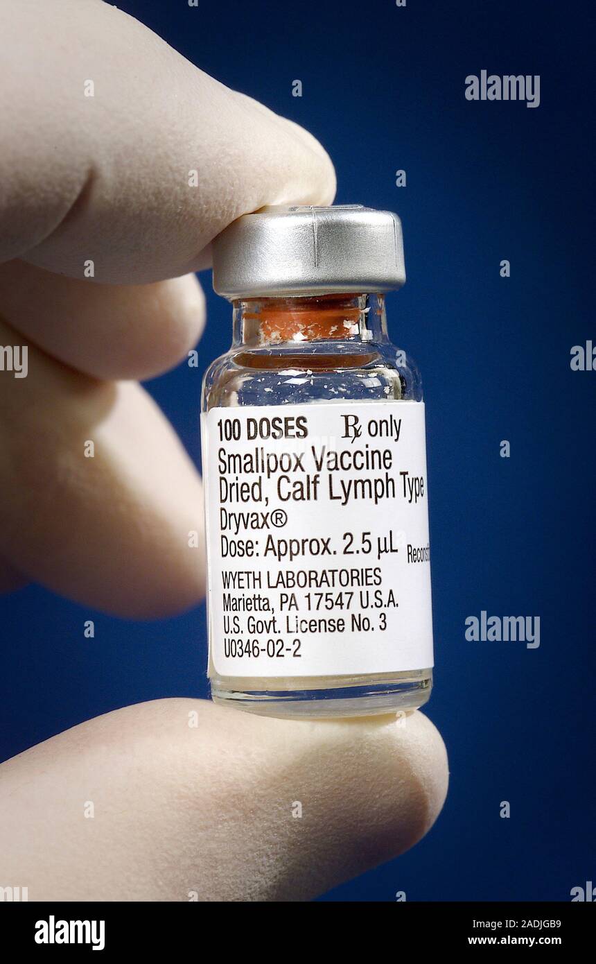 Smallpox vaccine. Gloved hand holding a phial containing Vaccinia ...