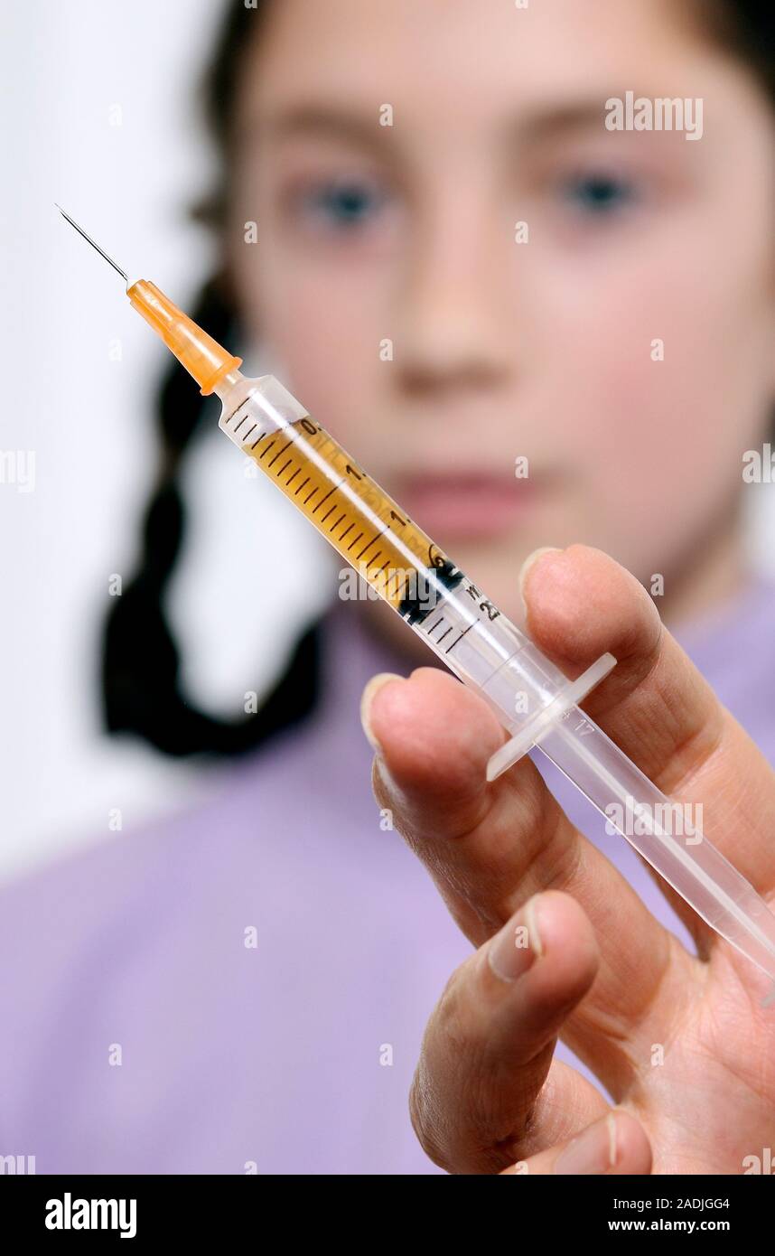 MODEL RELEASED. Preparing an injection whilst the patient looks on ...