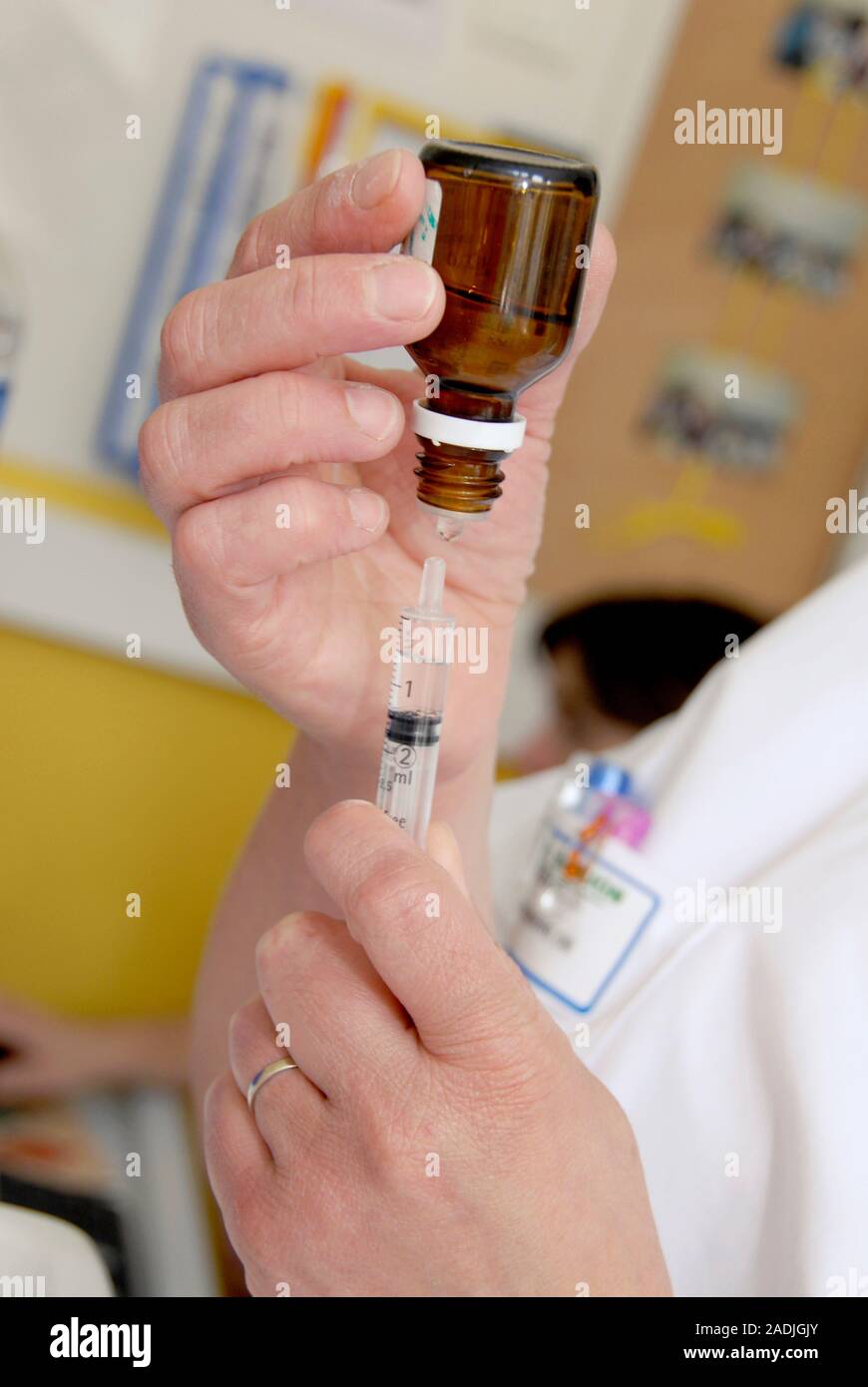 Preparing an injection. Nurse filling a syringe with a painkilling drug ...