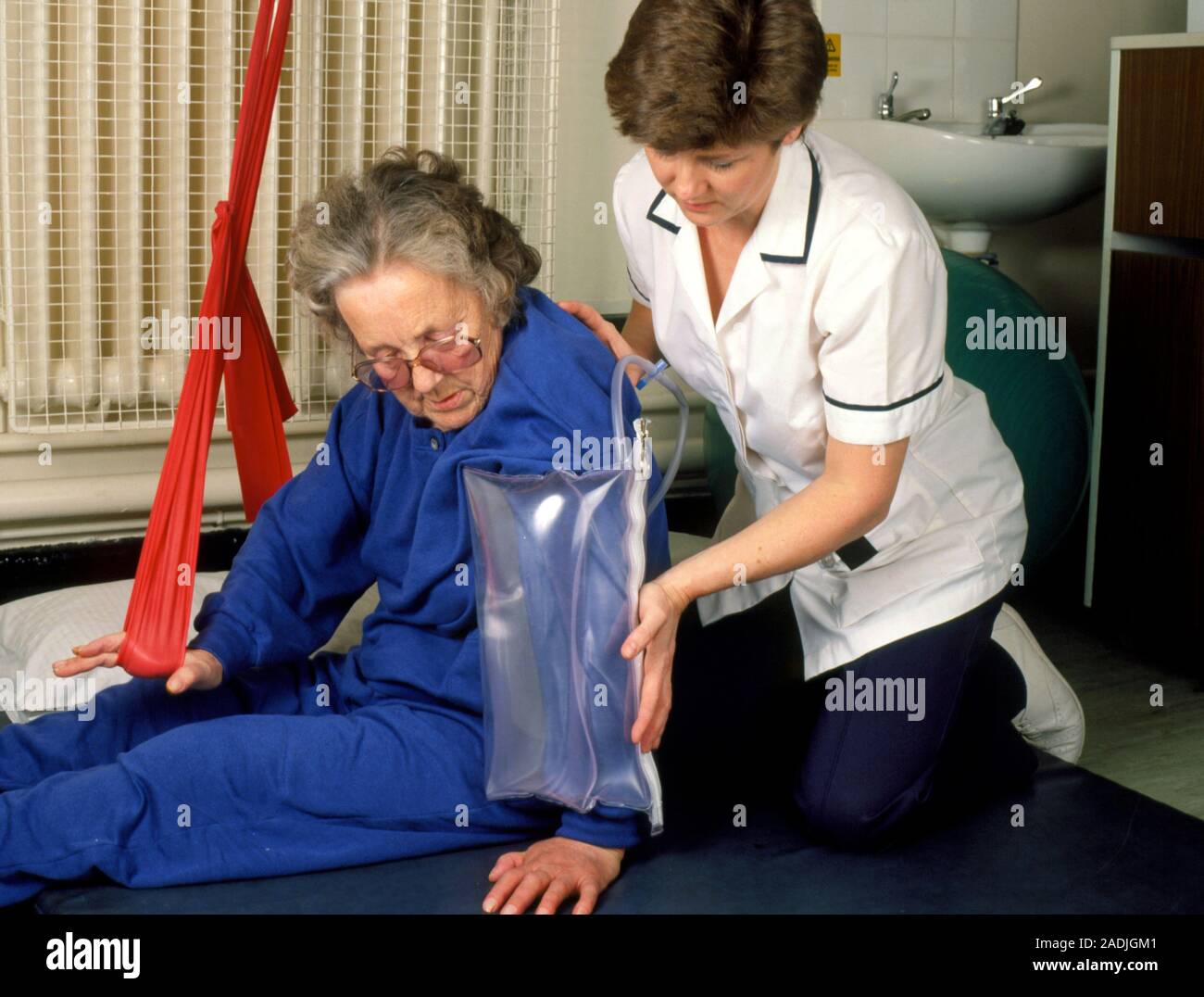 Stroke patient with left-side paralysis (hemiplegia), wearing an ...