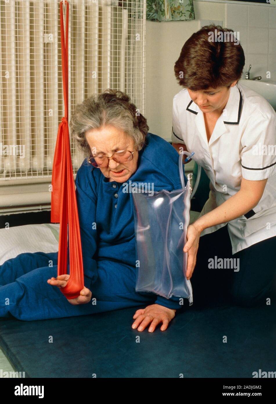 Stroke patient with from left-side paralysis (hemiplegia), wearing an ...