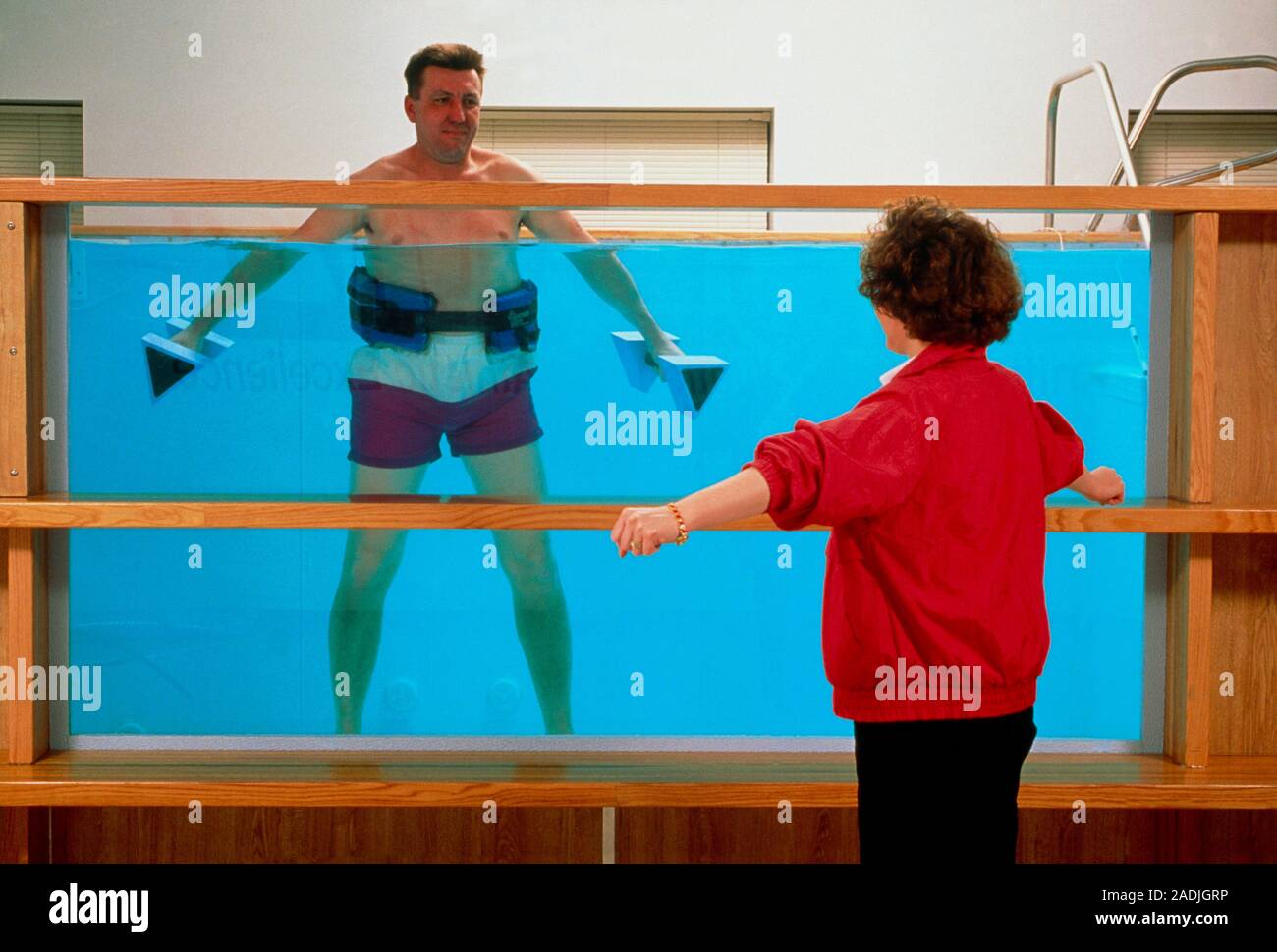 Hydrotherapy. Man exercises with weights in a hydrotherapy pool ...