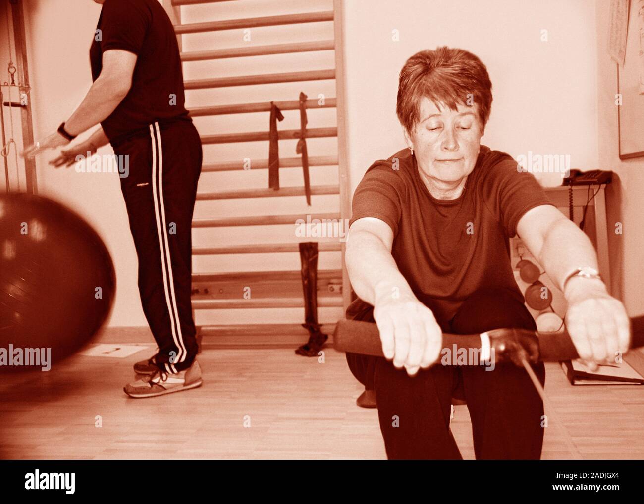 Physiotherapy. Patient rowing on a rowing machine during a ...