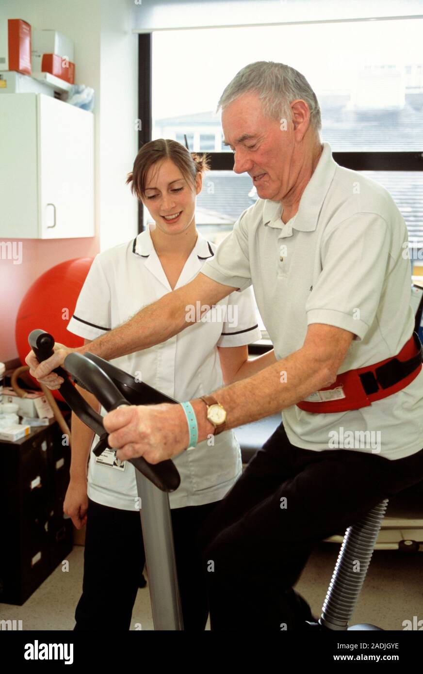 Physiotherapy. Male stroke patient exercising on a high-tech bicycle as ...