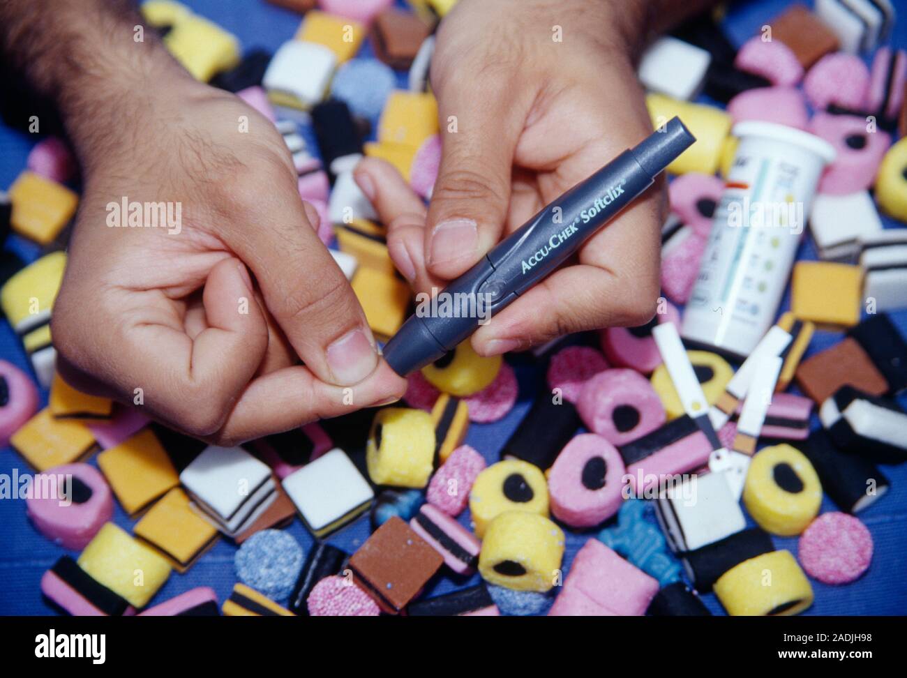 Blood glucose test. Hands of a patient using a pen-like lancing device ...