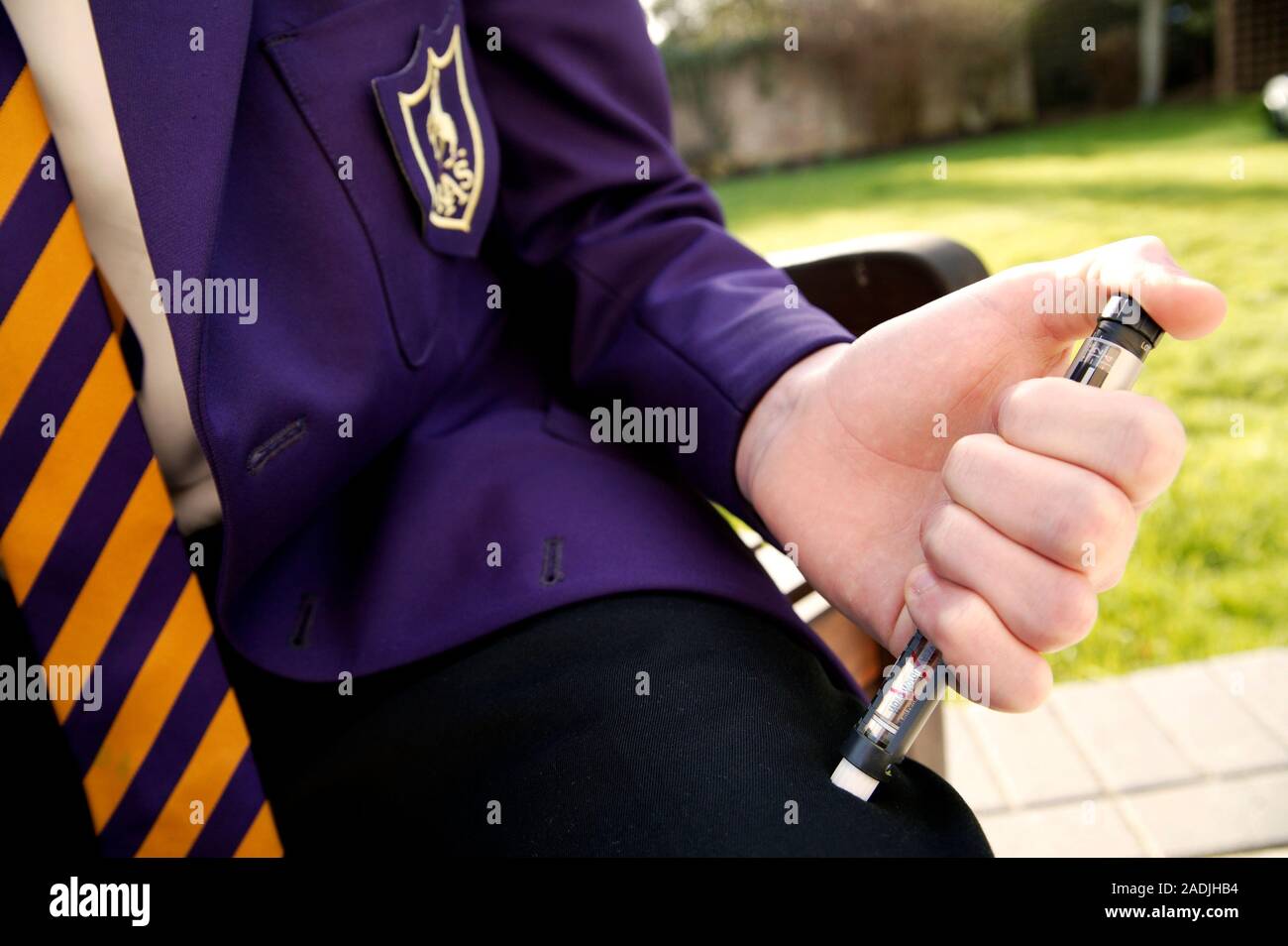 Insulin injection. 16-year-old schoolboy injecting himself in the leg ...