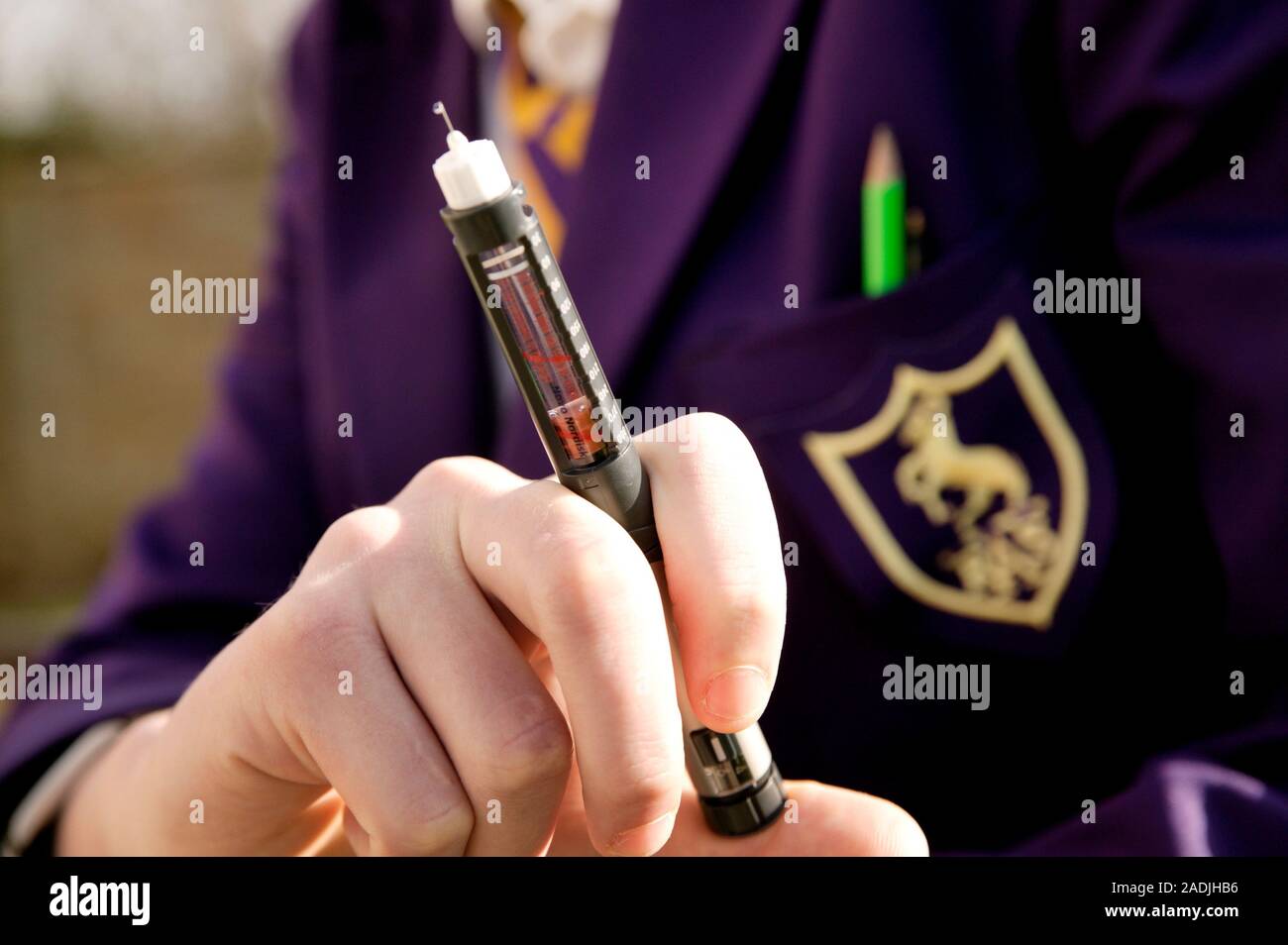 Insulin injector. 16-year-old schoolboy preparing to inject himself ...
