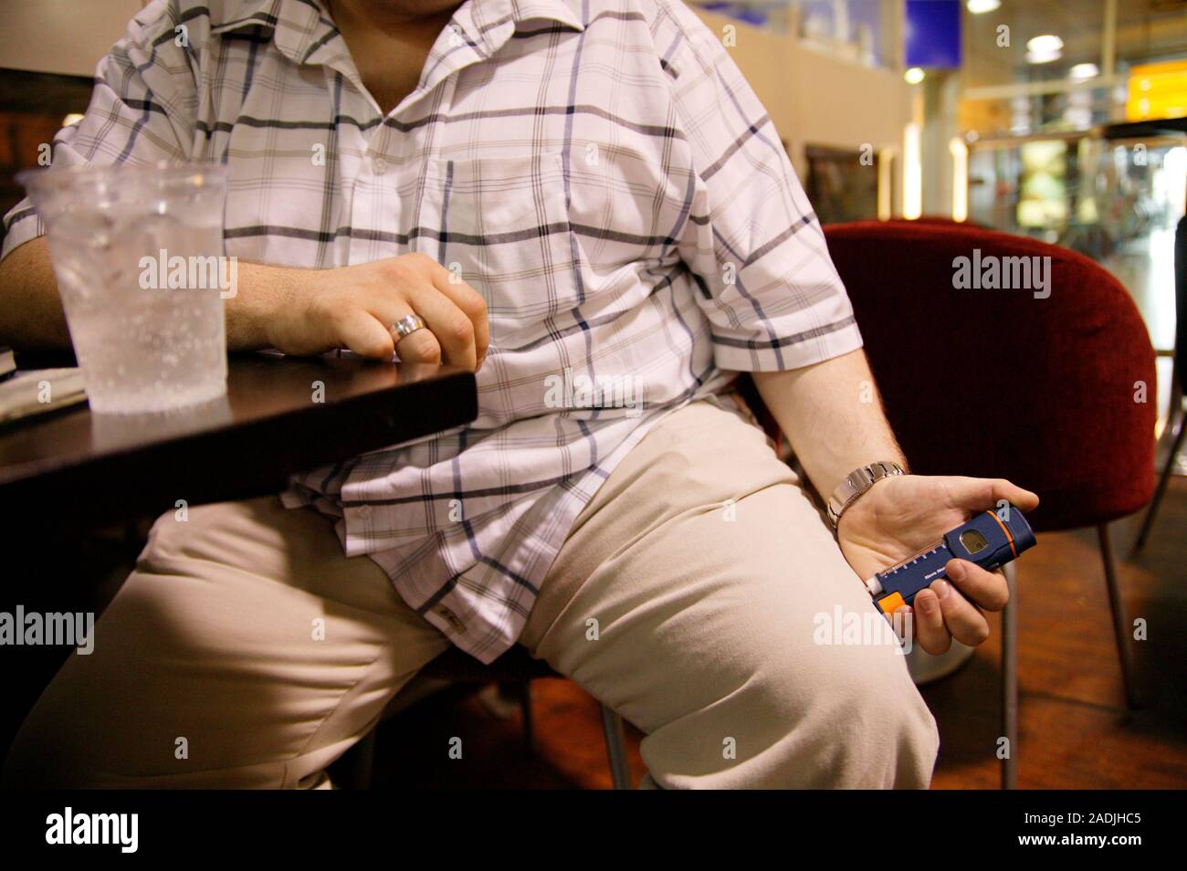 Insulin injection. Diabetic man injecting himself in the leg with ...