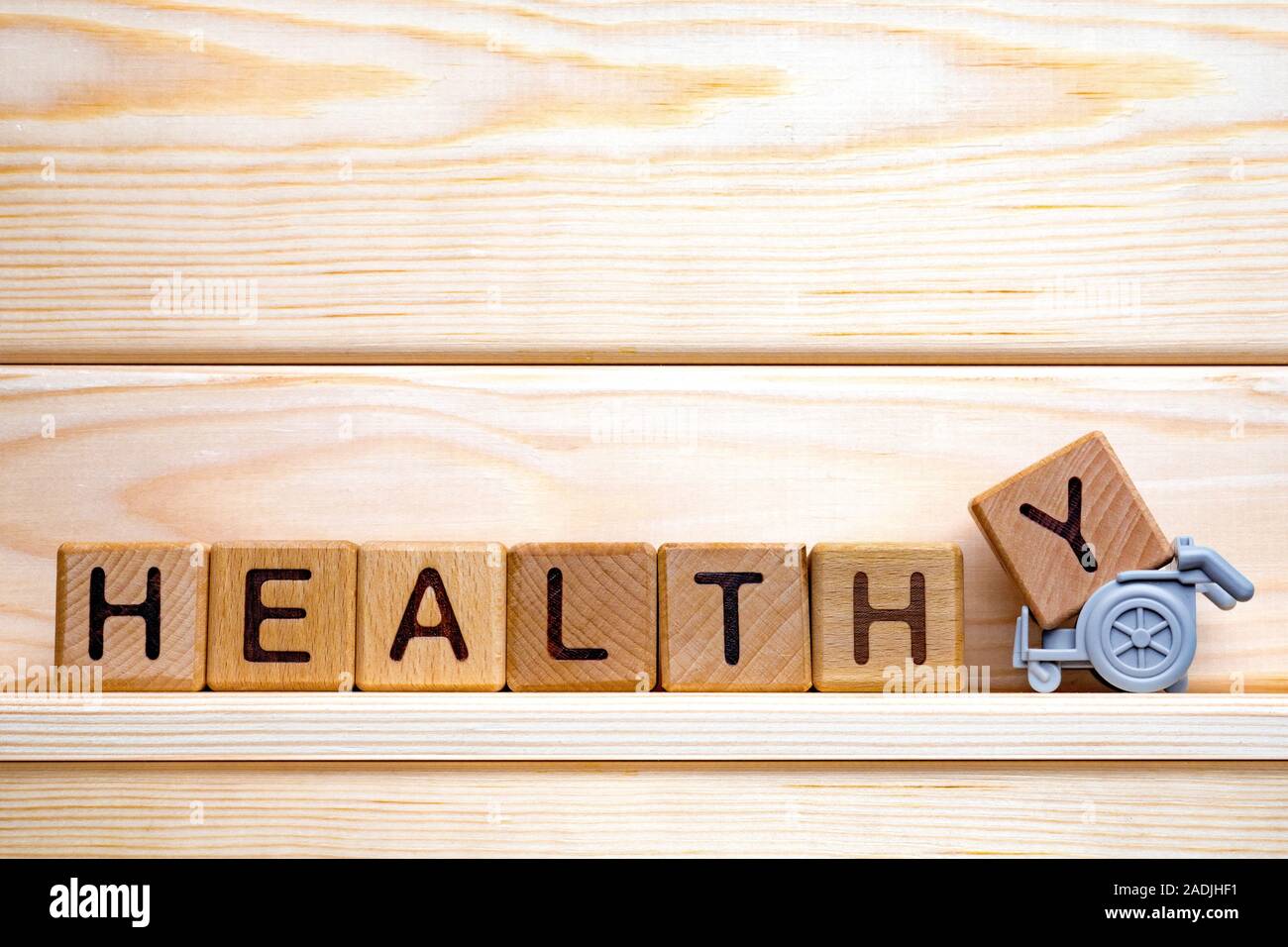 Healthy word made of wood cubes on wood background. Healthy sign ...