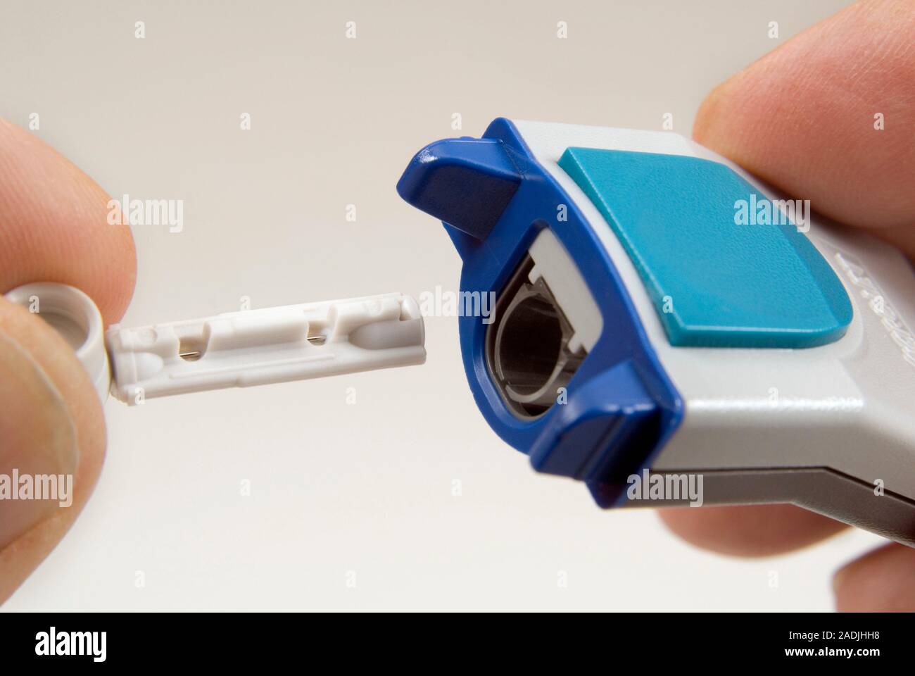 Blood glucose test. Lancet containing a blood sample being used to test ...