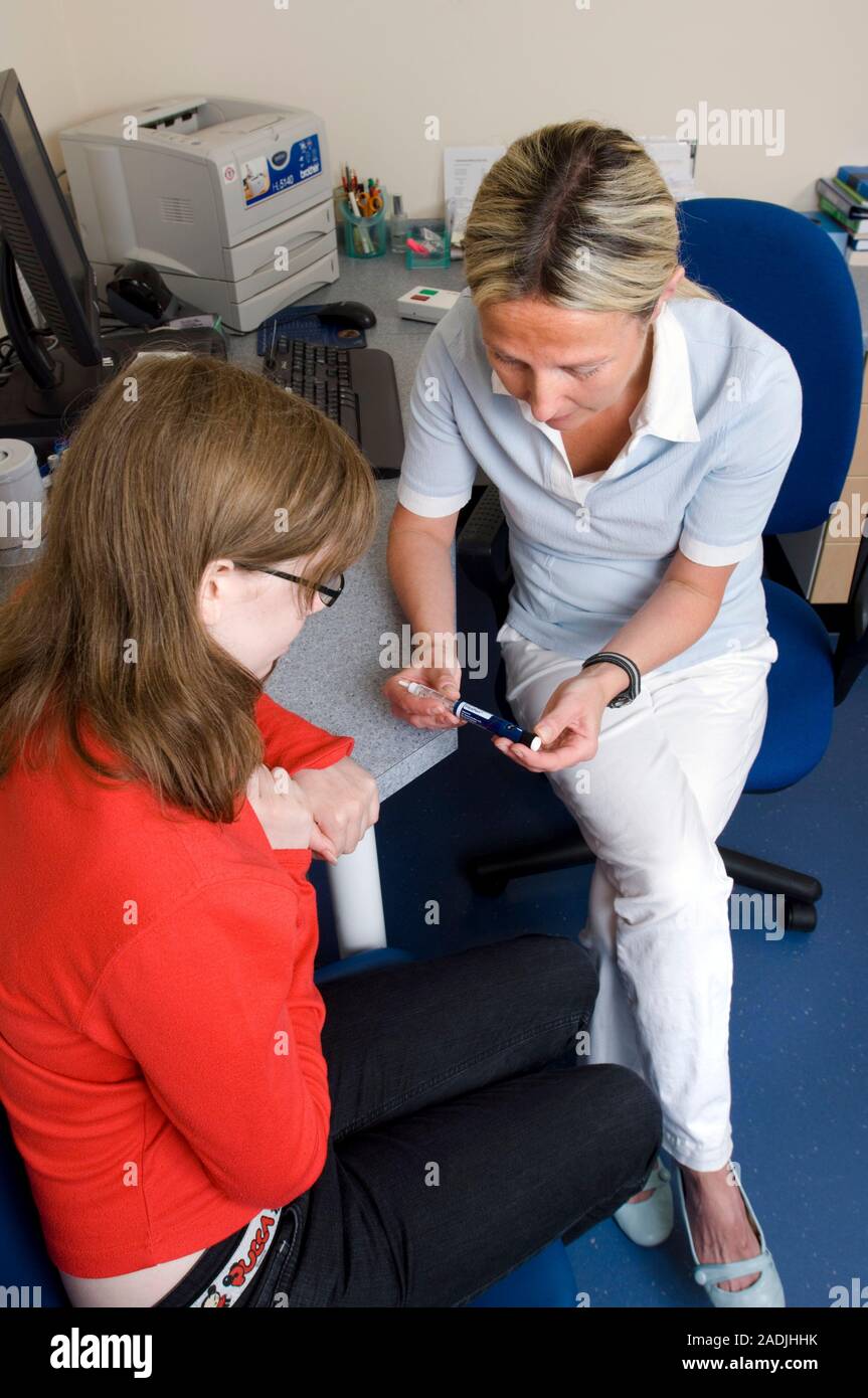 Insulin pen instruction. Healthcare worker showing a patient how to use ...