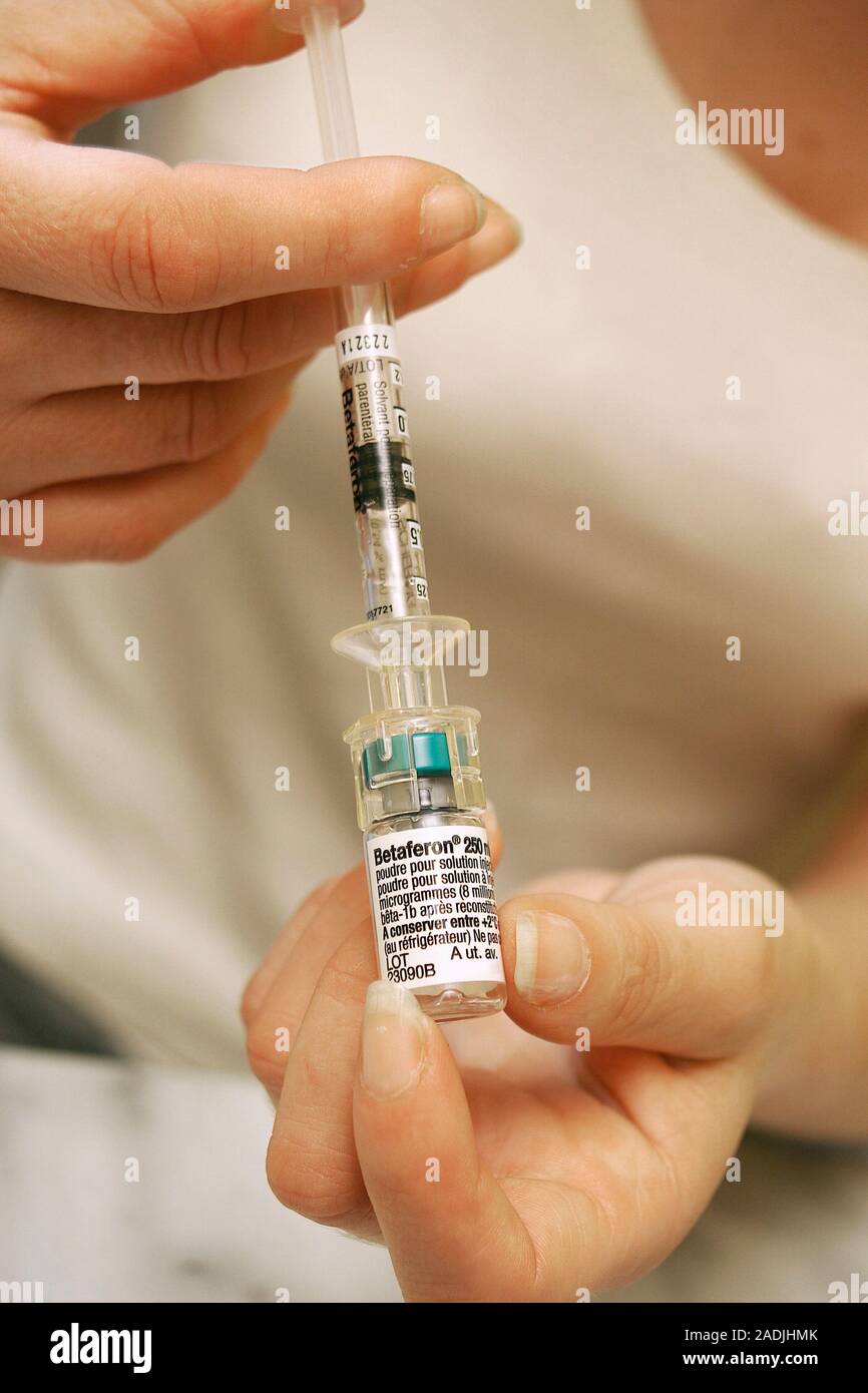 Multiple sclerosis treatment. Woman's hands using a syringe to draw ...