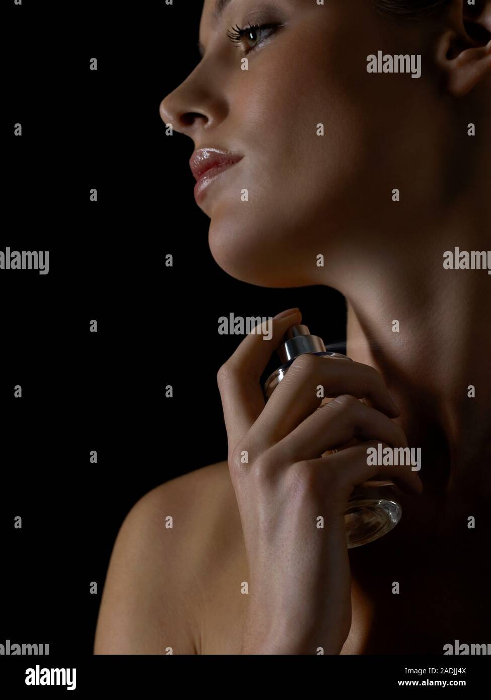 MODEL RELEASED. Perfume. Woman spraying herself with fragrance Stock ...
