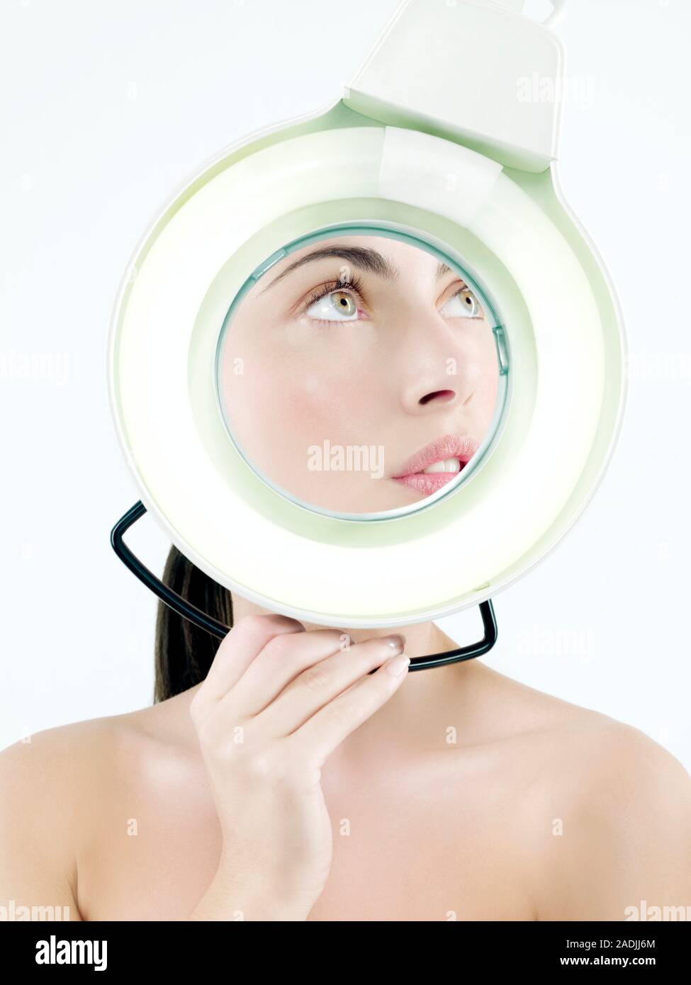 MODEL RELEASED. Skin examination. Woman's face magnified beneath a ...
