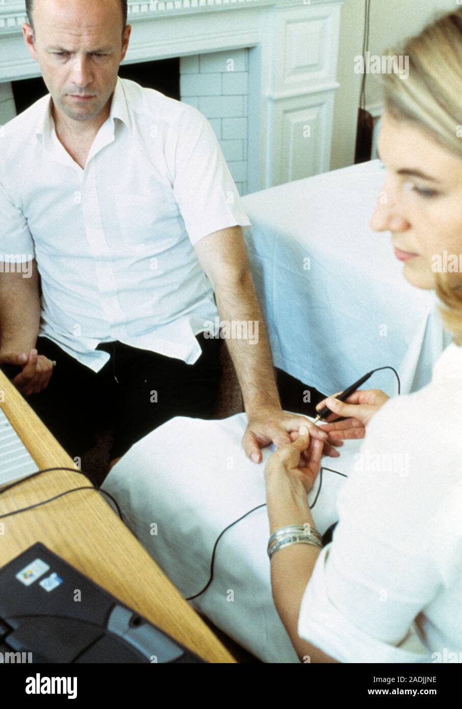 Allergy testing. Complementary medicine practitioner holding a sensor ...