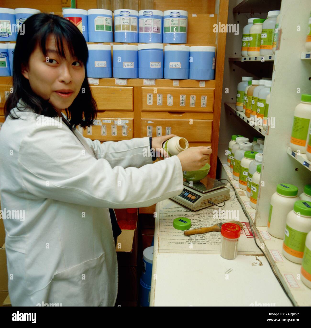Chinese pharmacy. Pharmacist dispenses herbal medication at a Chinese ...