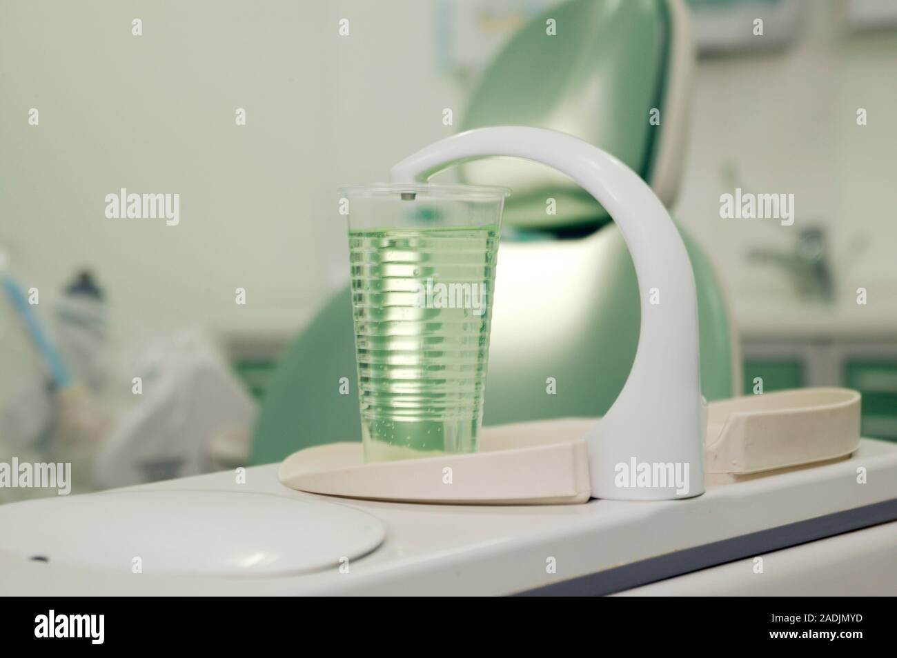 Glass of mouth rinse in a dental treatment room. Antimicrobial mouth ...