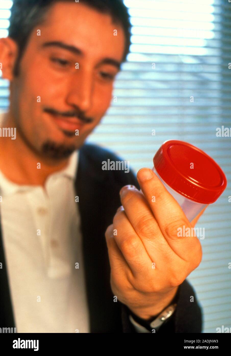 Artificial insemination (image 5 of 9). Man holding a jar containing a ...